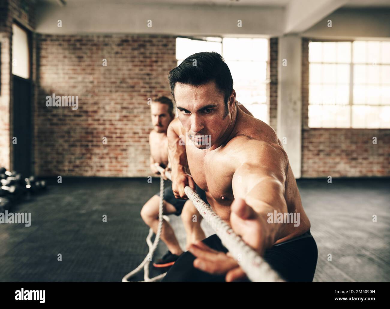 Keep pulling. two fit and determined young men making use of ropes to ...