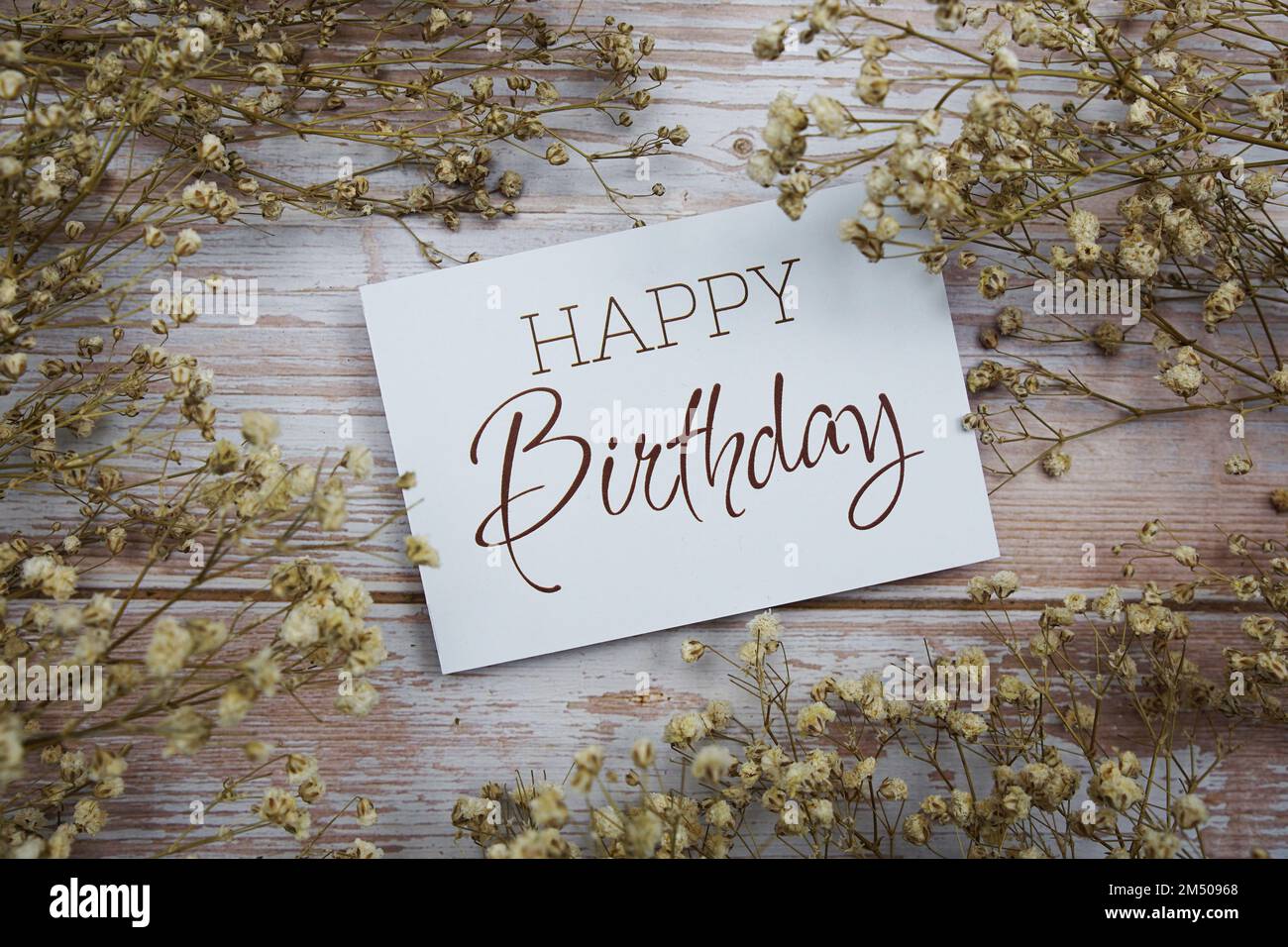 Happy Birthday text on paper card with flower decoration on wooden ...