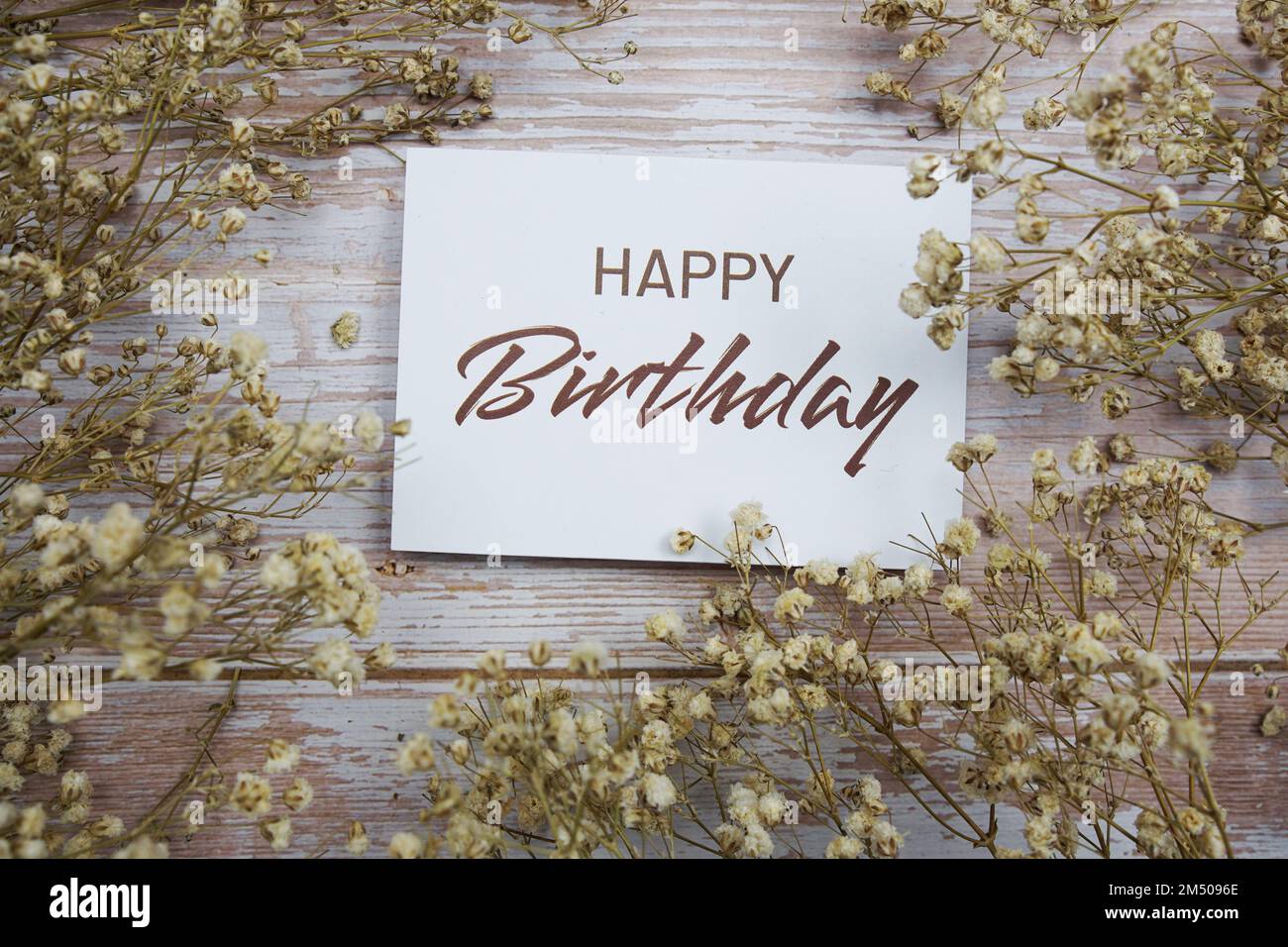 Happy Birthday text on paper card with flower decoration on wooden ...