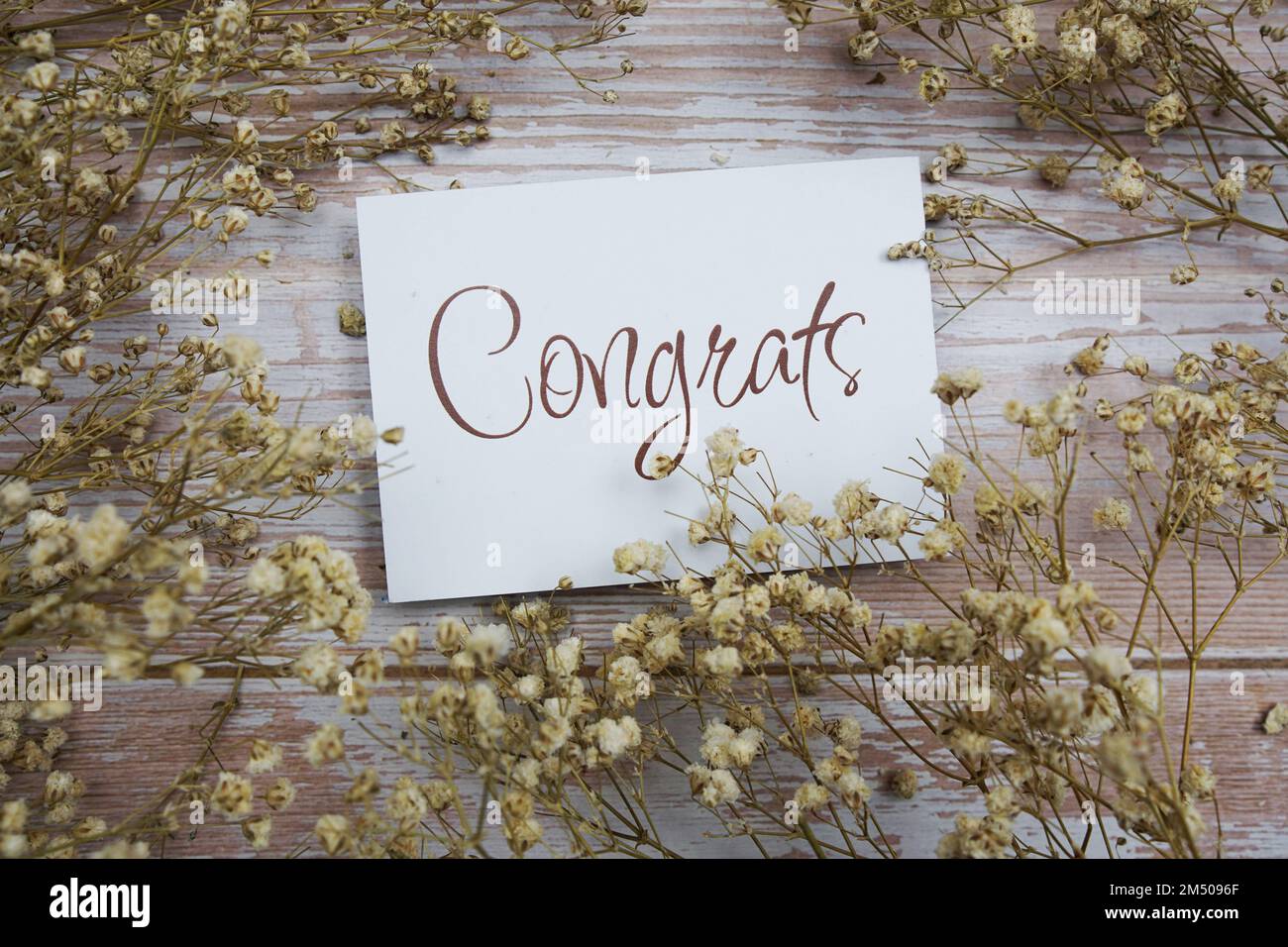 Congrats text on paper card with flower decoration on wooden background ...