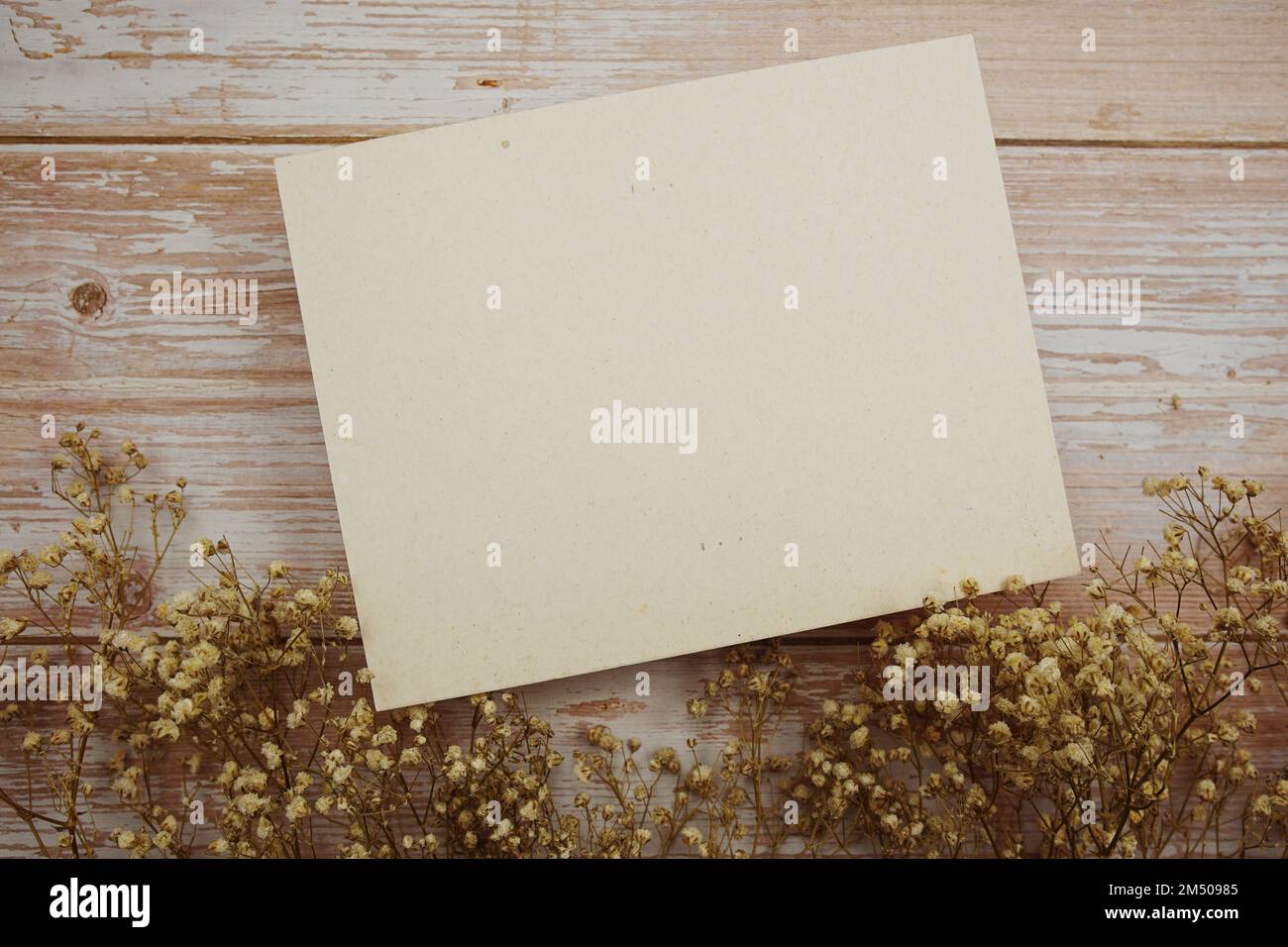 Empty card for text message and flower decoration on wooden background ...