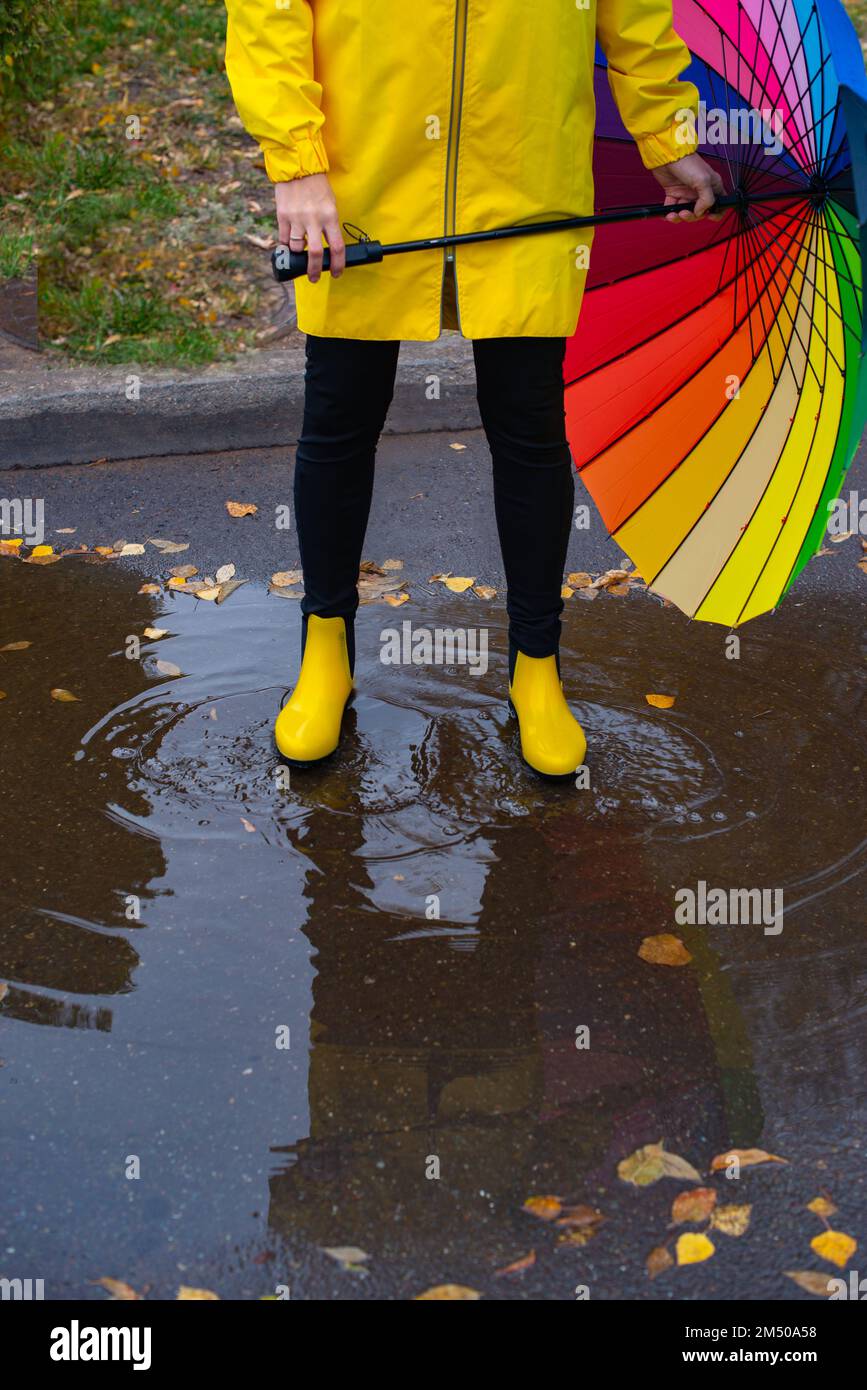 one multi-colored umbrella and yellow boots in a puddle Stock Photo - Alamy