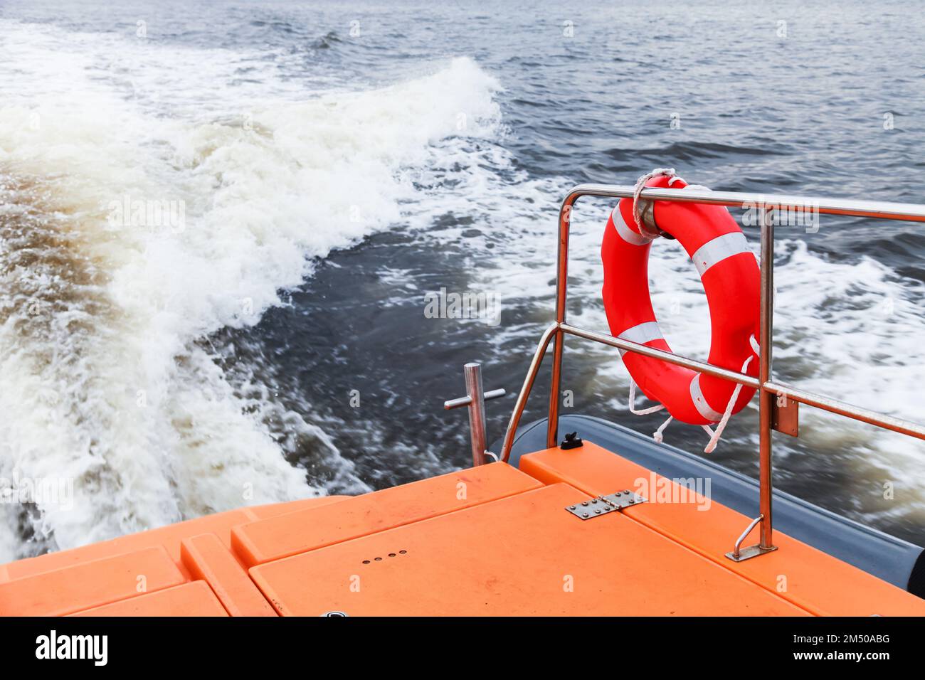 Red lifebuoy hangs on metal railings of fast pilot boat Stock Photo - Alamy
