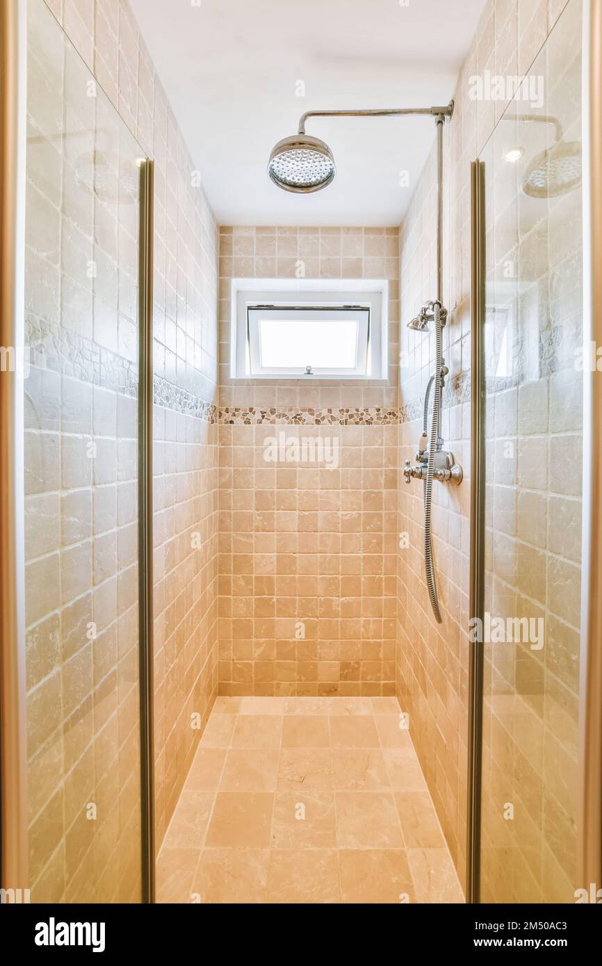 a walk in shower with tiled walls and beige tile on the floor, along ...