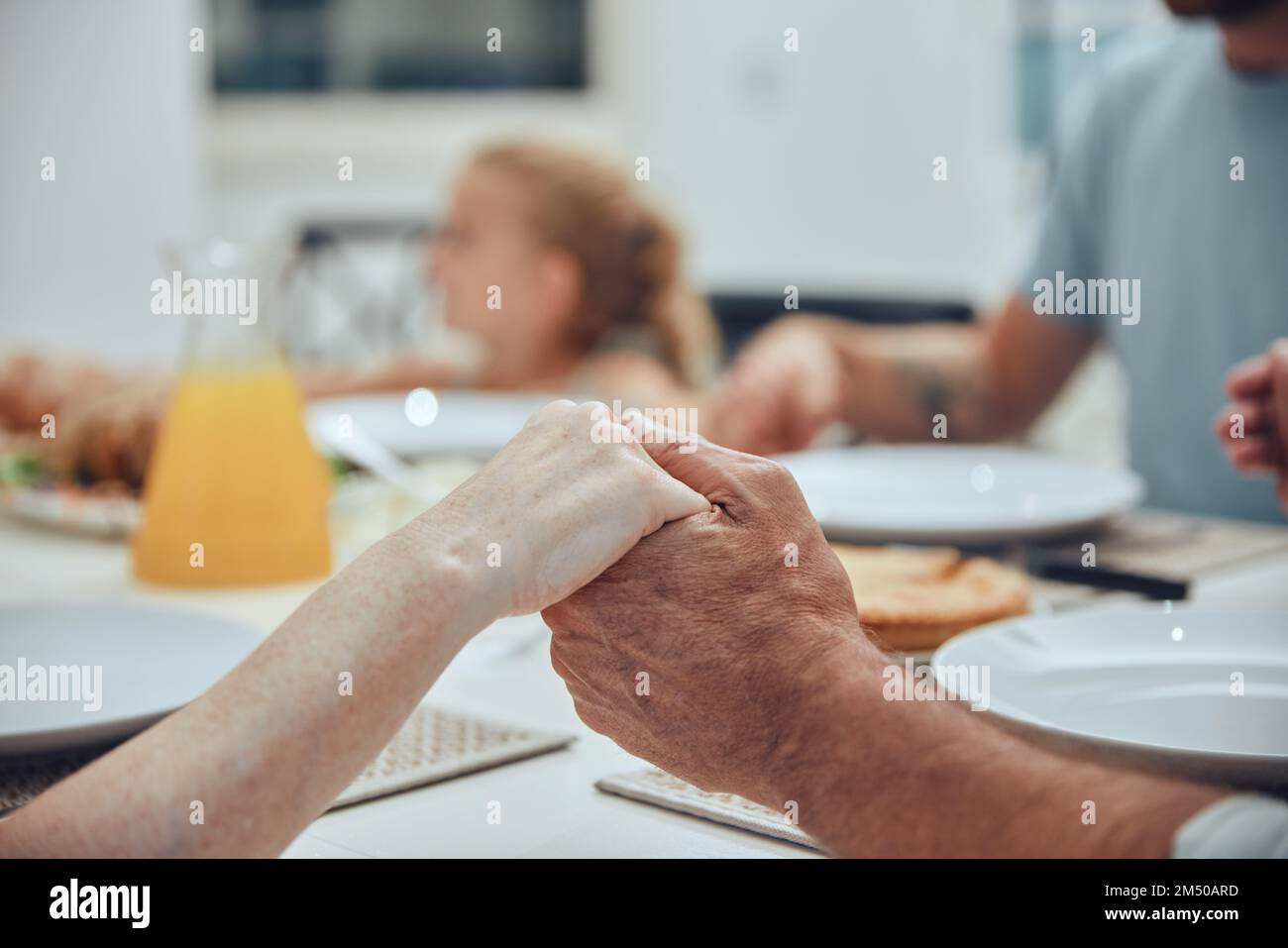 Family, holding hands and praying for lunch in home dining room table ...