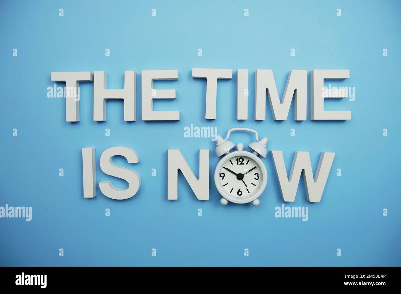 The Time is Now alphabet letters on blue background Stock Photo - Alamy