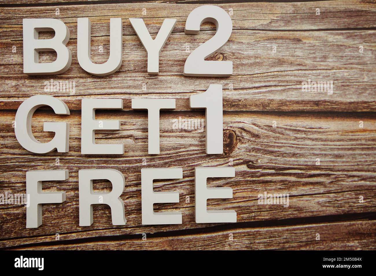 Buy 2 Get 1 Free alphabet letters on wooden background Stock Photo - Alamy