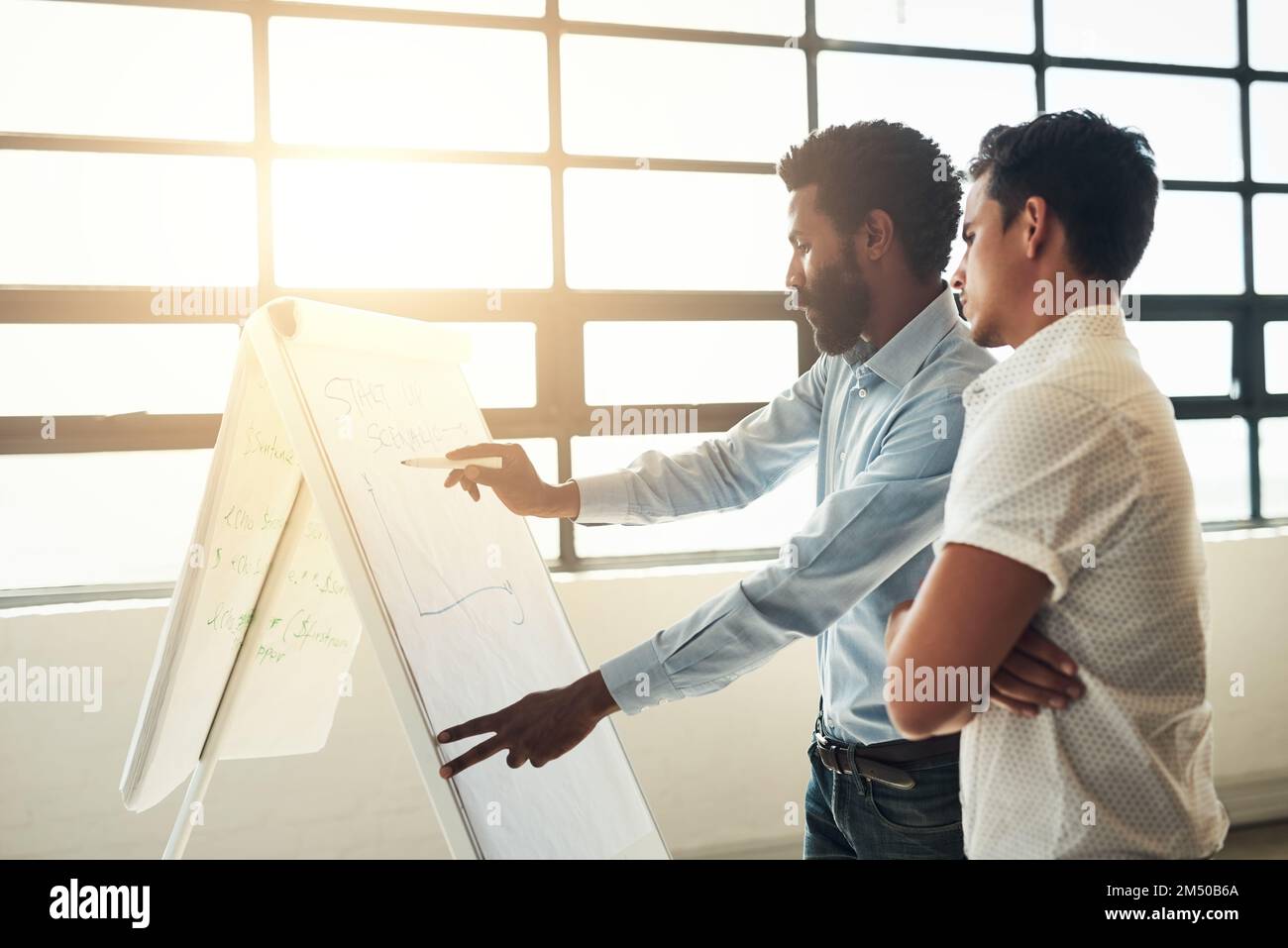 Charting their success. two businessmen brainstorming together in an ...