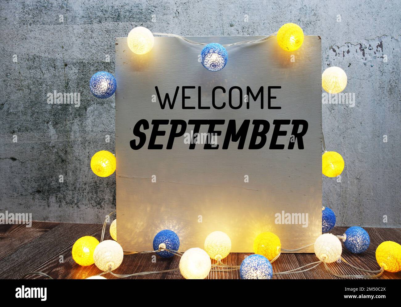 Welcome September text message with LED cotton balls decorate on wooden ...