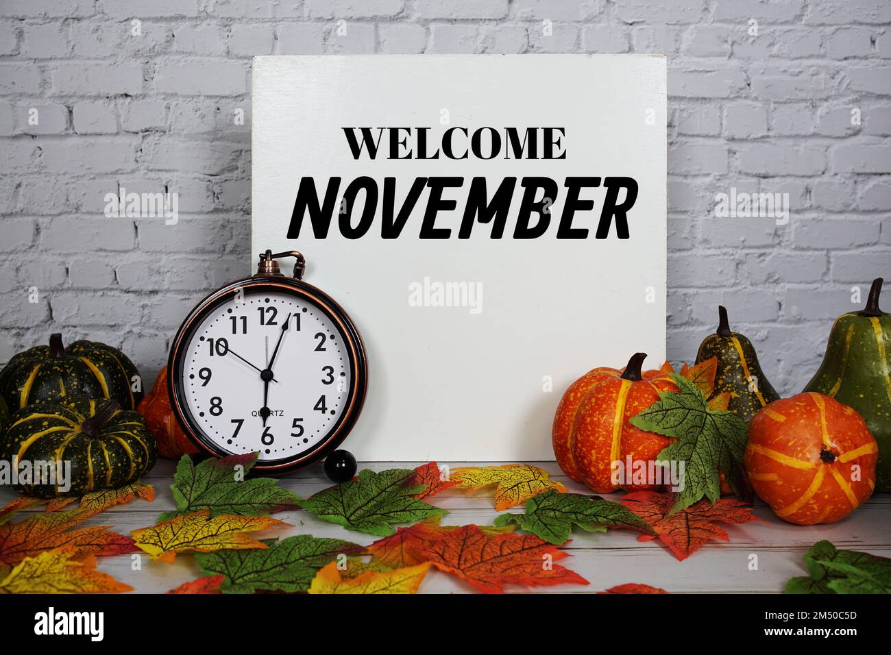 Welcome November text message with pumpkin and maple leaf decoration on ...