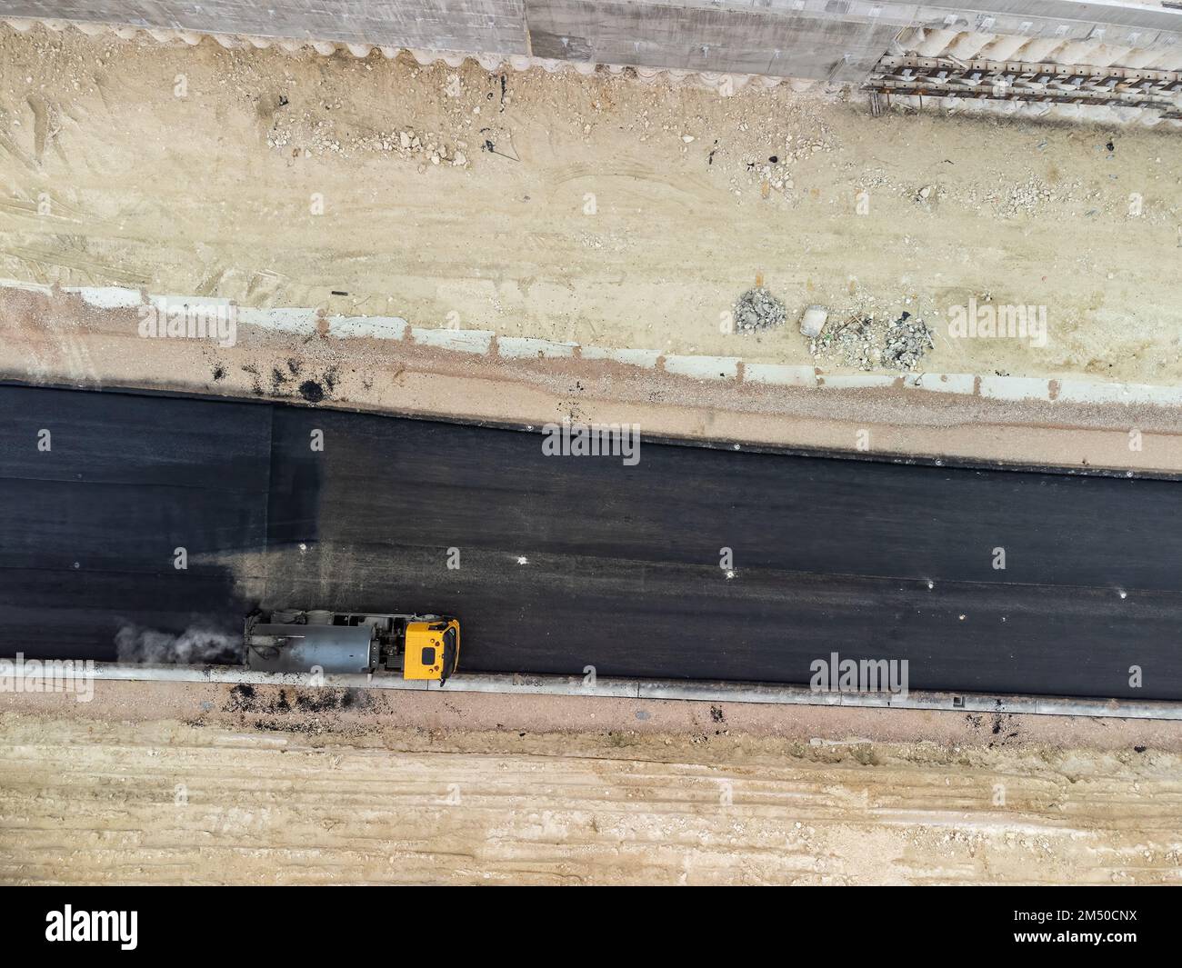 yellow truck pouring bitumen over a new road. Aerial drone shot. Road ...
