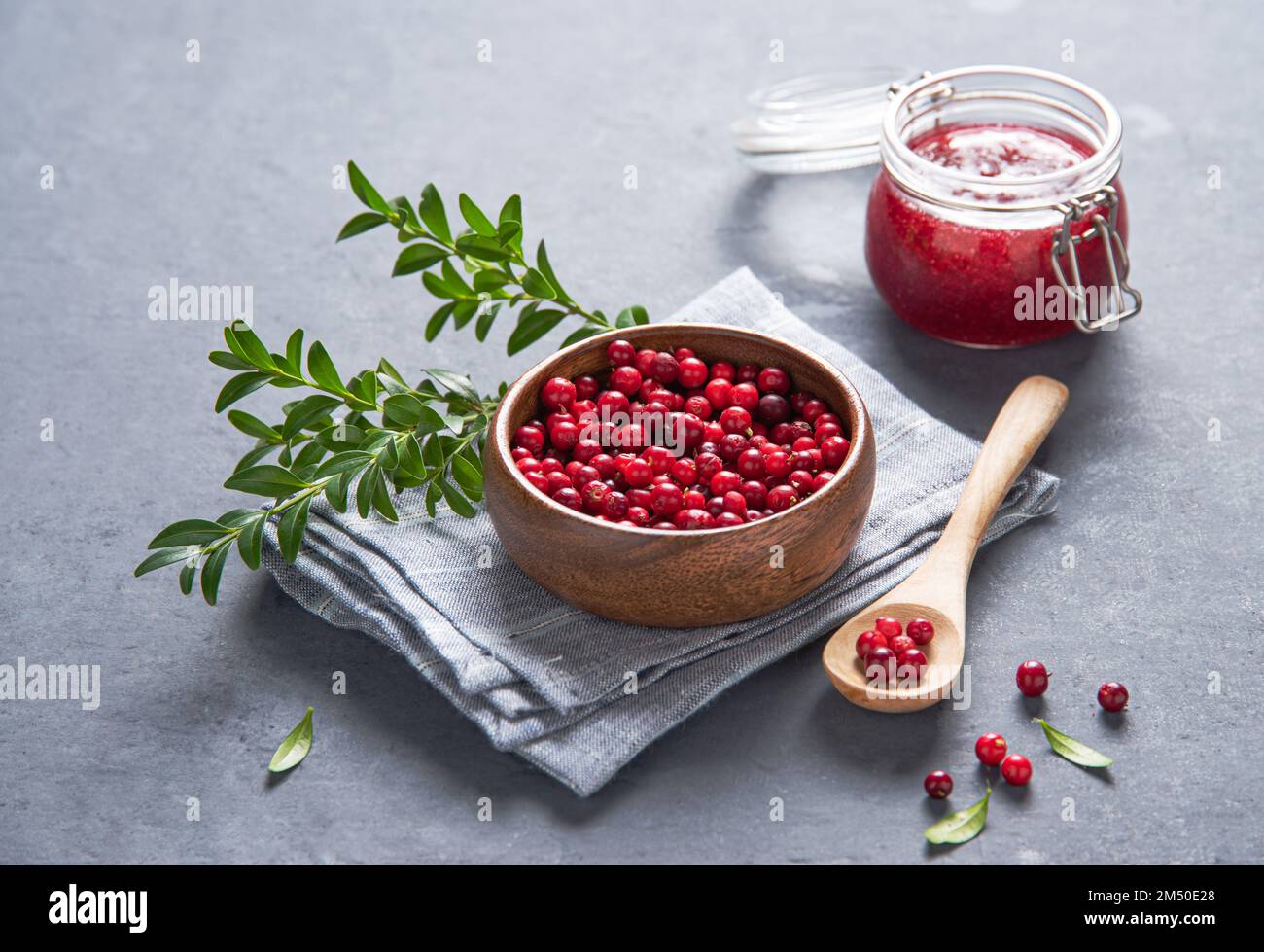 juicy forest lingonberry in a wooden bowl and handmade jam in jar on ...