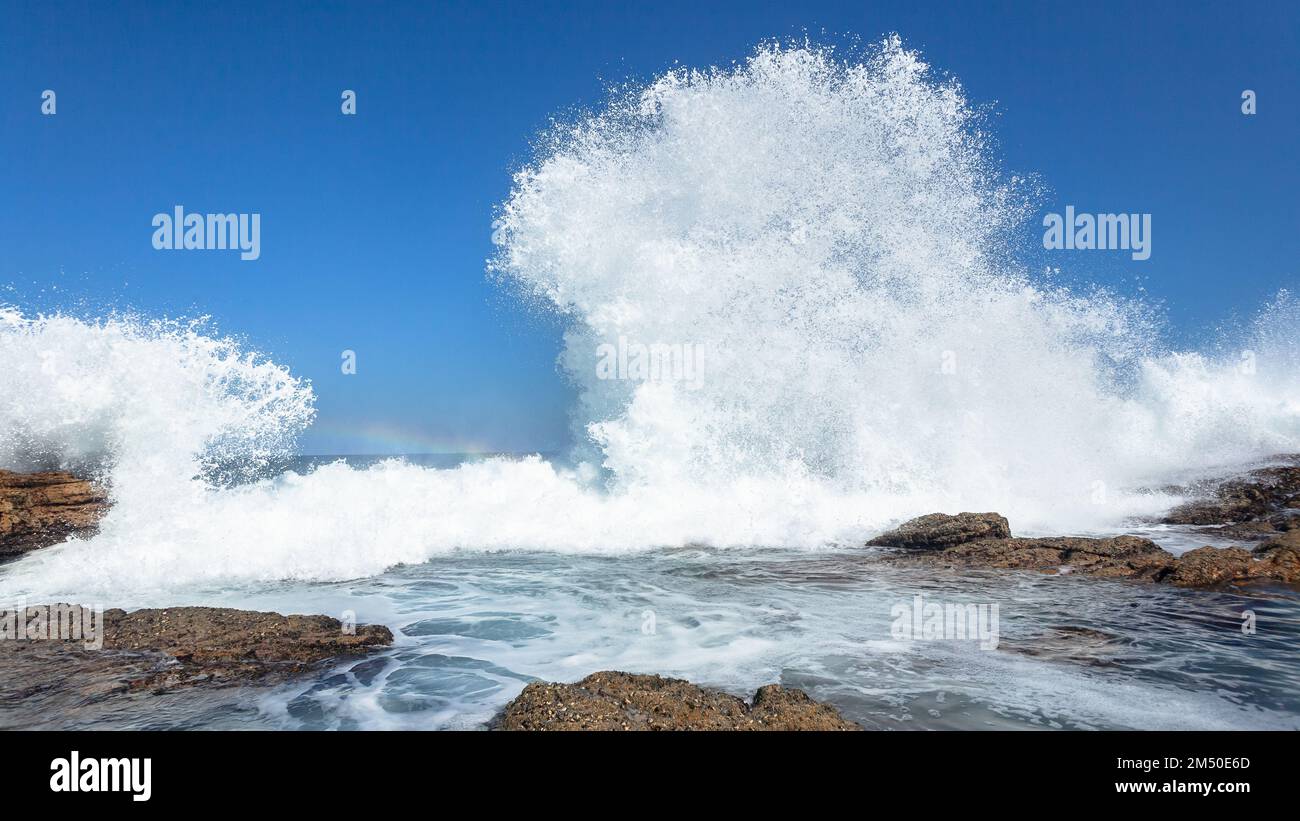 Wave rocks crashing exploding white ocean sea water spray power into ...