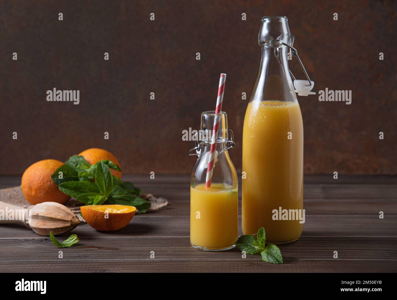 freshly squeezed orange juice in two bottles with citrus fruits on a ...