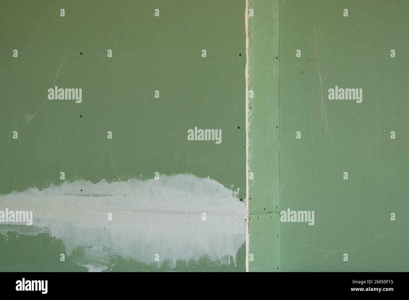 drywall wall of green color as a background Stock Photo - Alamy