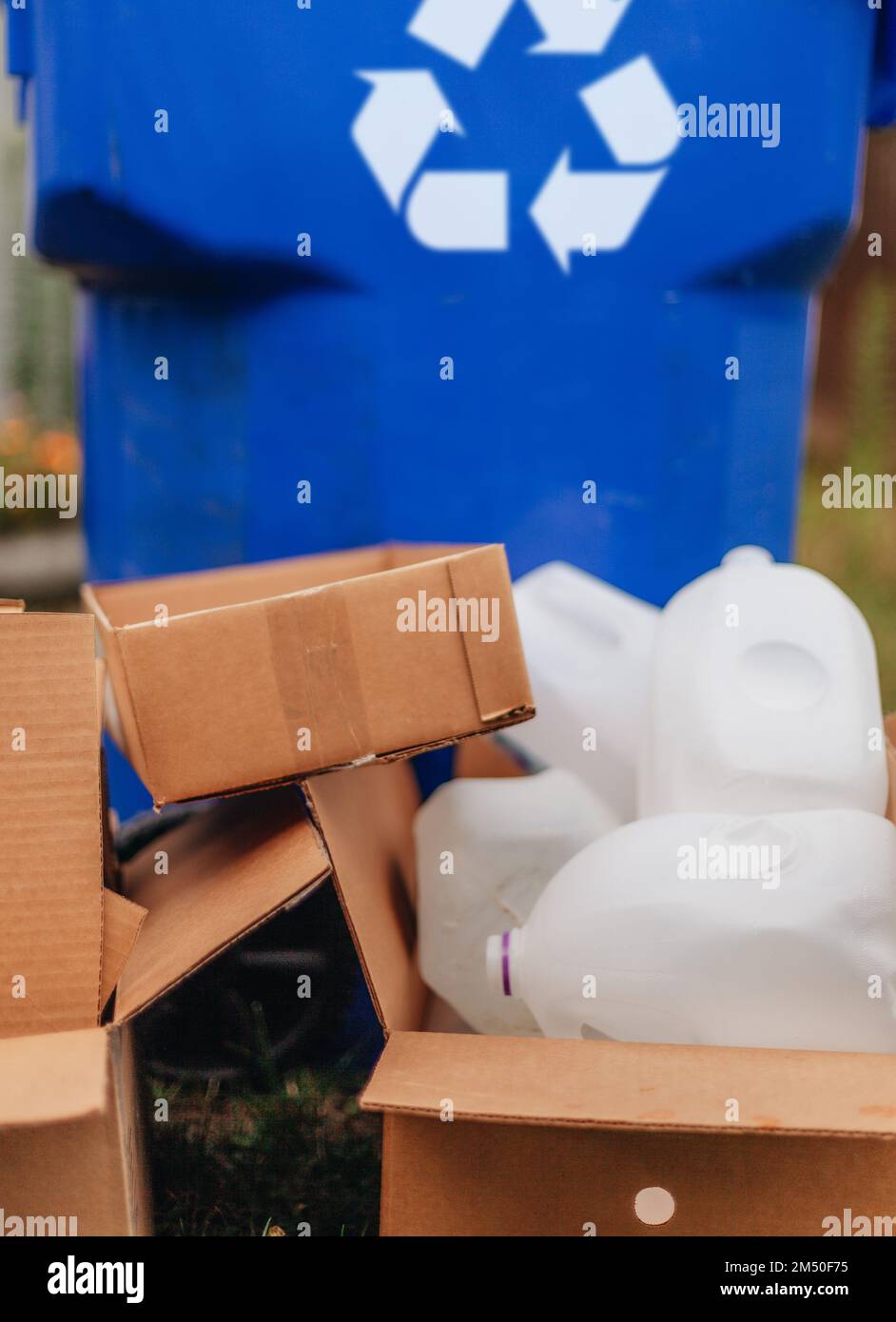 A vertical shot of plastic and cardboard boxes placed next to a blue ...