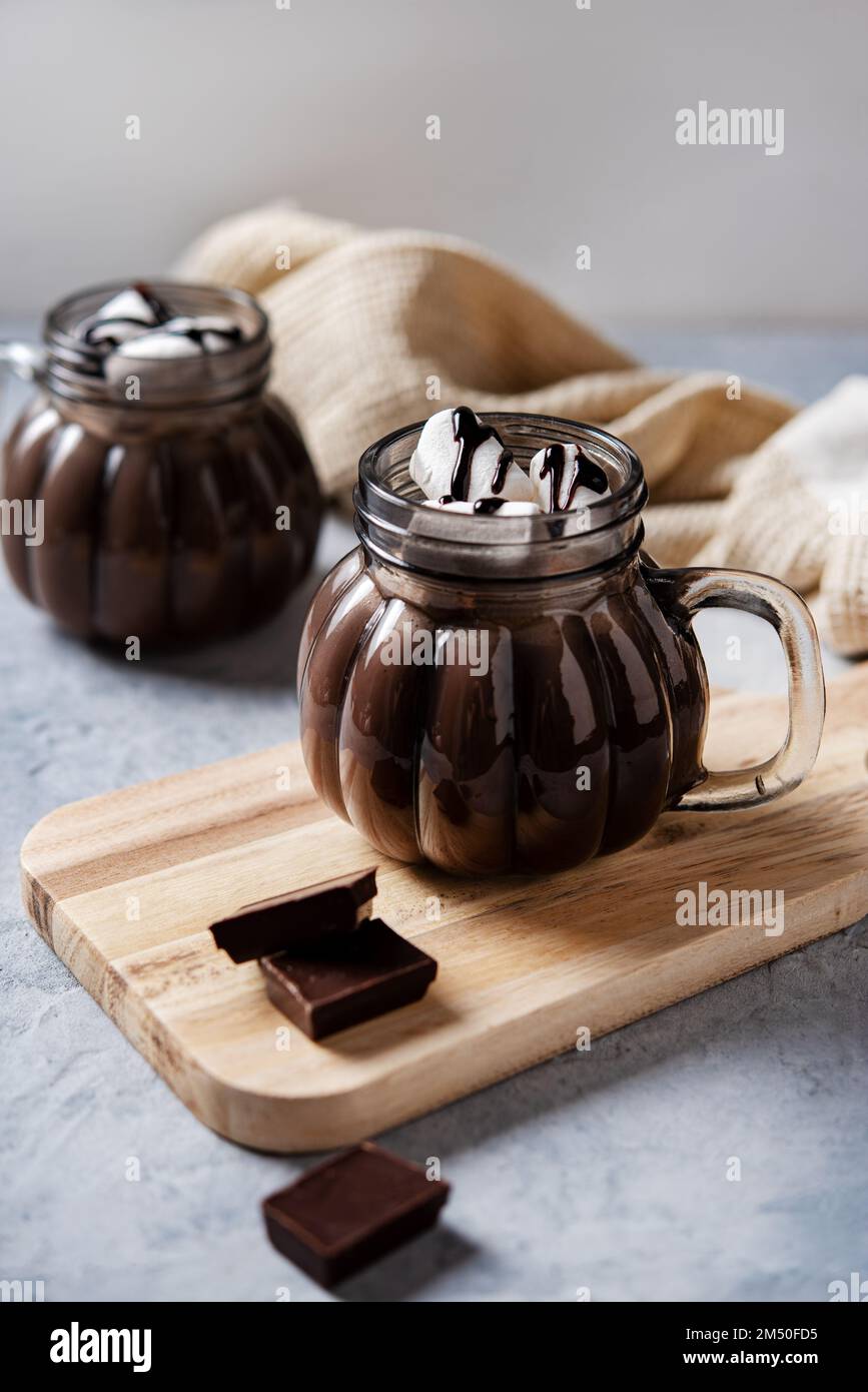 Two cups of aroma hot chocolate with marshmallows on a blue background ...