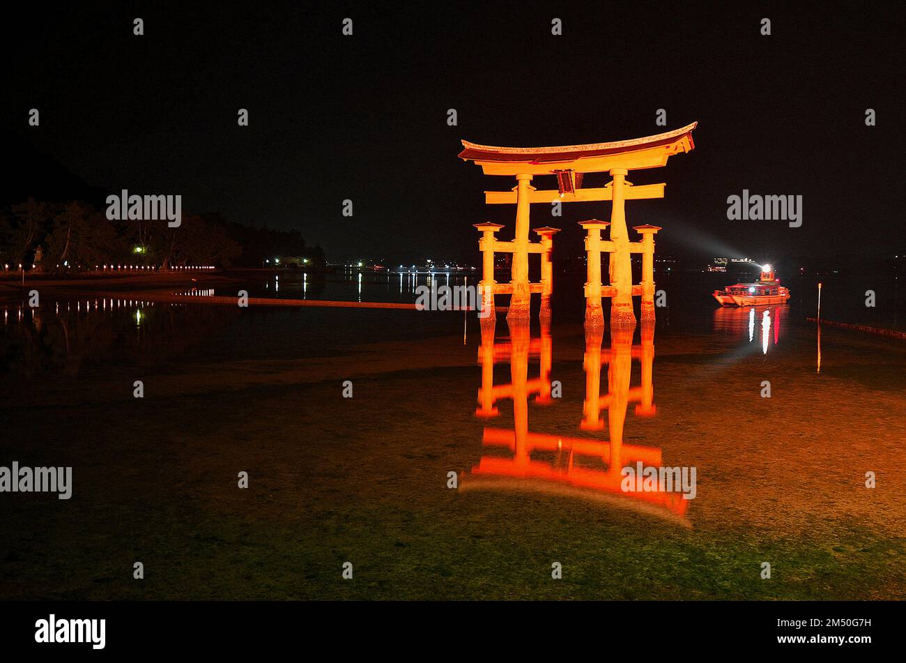 Torii gate and ferry boat at night in Miyajima island, Itsukushima ...