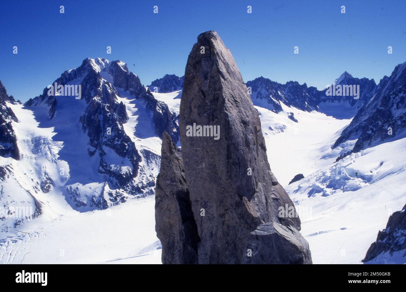 A closeup of big rock on a snowy mountain under blue sky Stock Photo ...