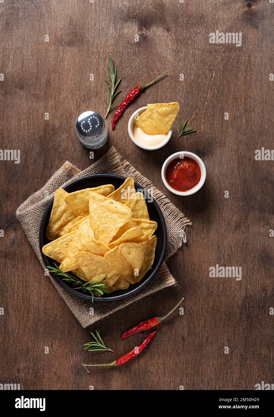 Corn chips nachos with salsa and cream sauce, herbs, salt and chili ...