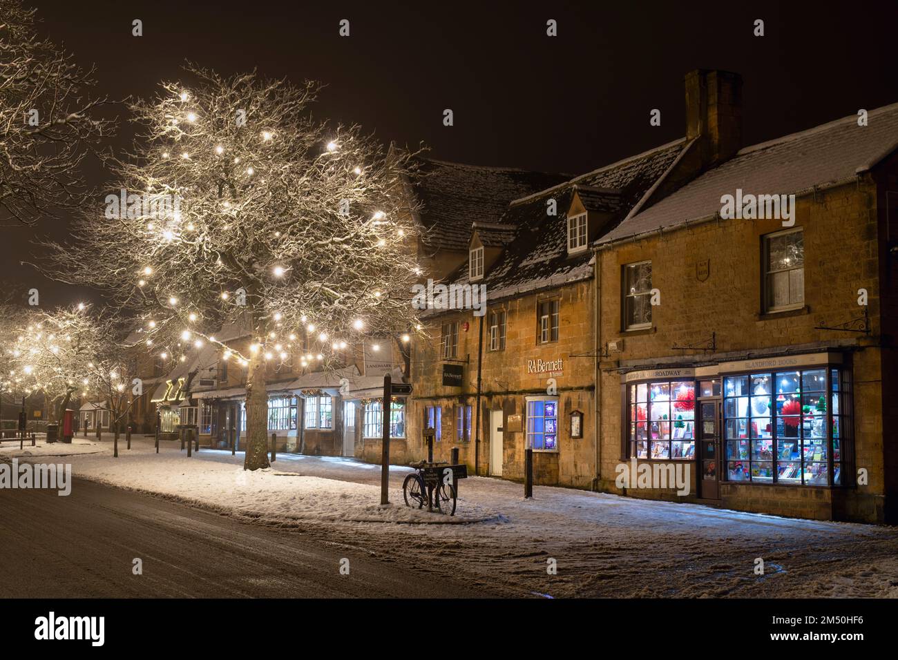 Christmas lights along the high street at night in the snow. Broadway, Cotswolds, Worcestershire ...