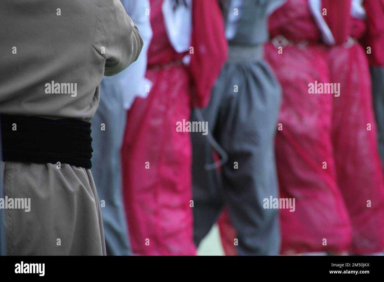 A low-angle shot of people wearing traditional clothes while dancing a ...