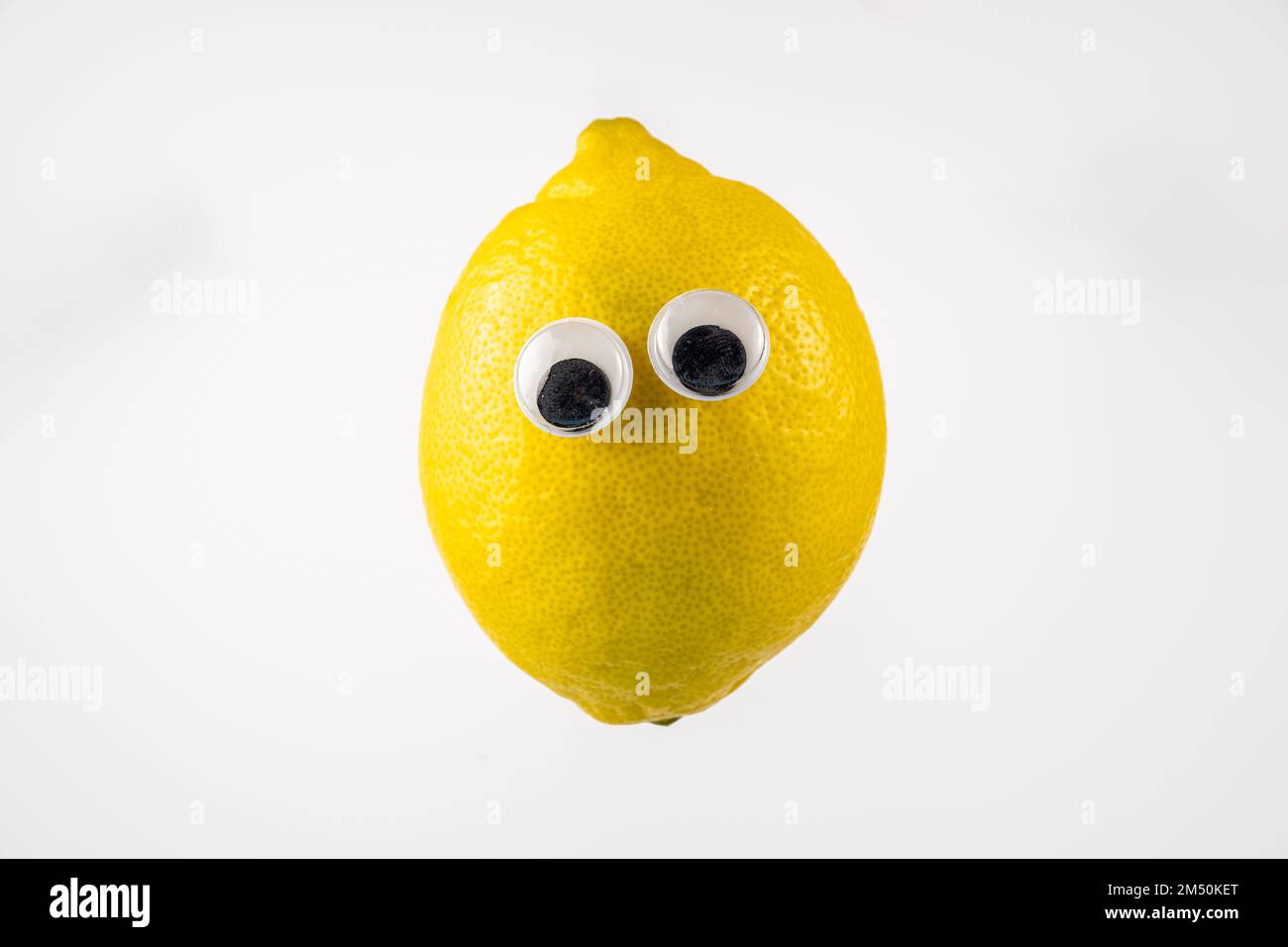 solitary funny lemon with googly eyes isolated on a white background ...