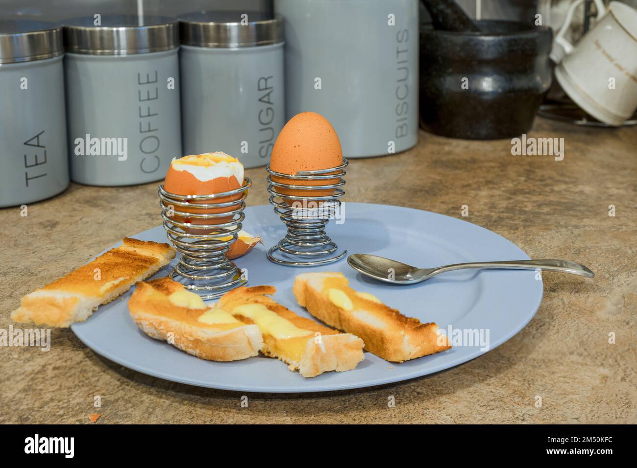 two boiled eggs in chrome wire egg cups with toasted bread soldiers ...