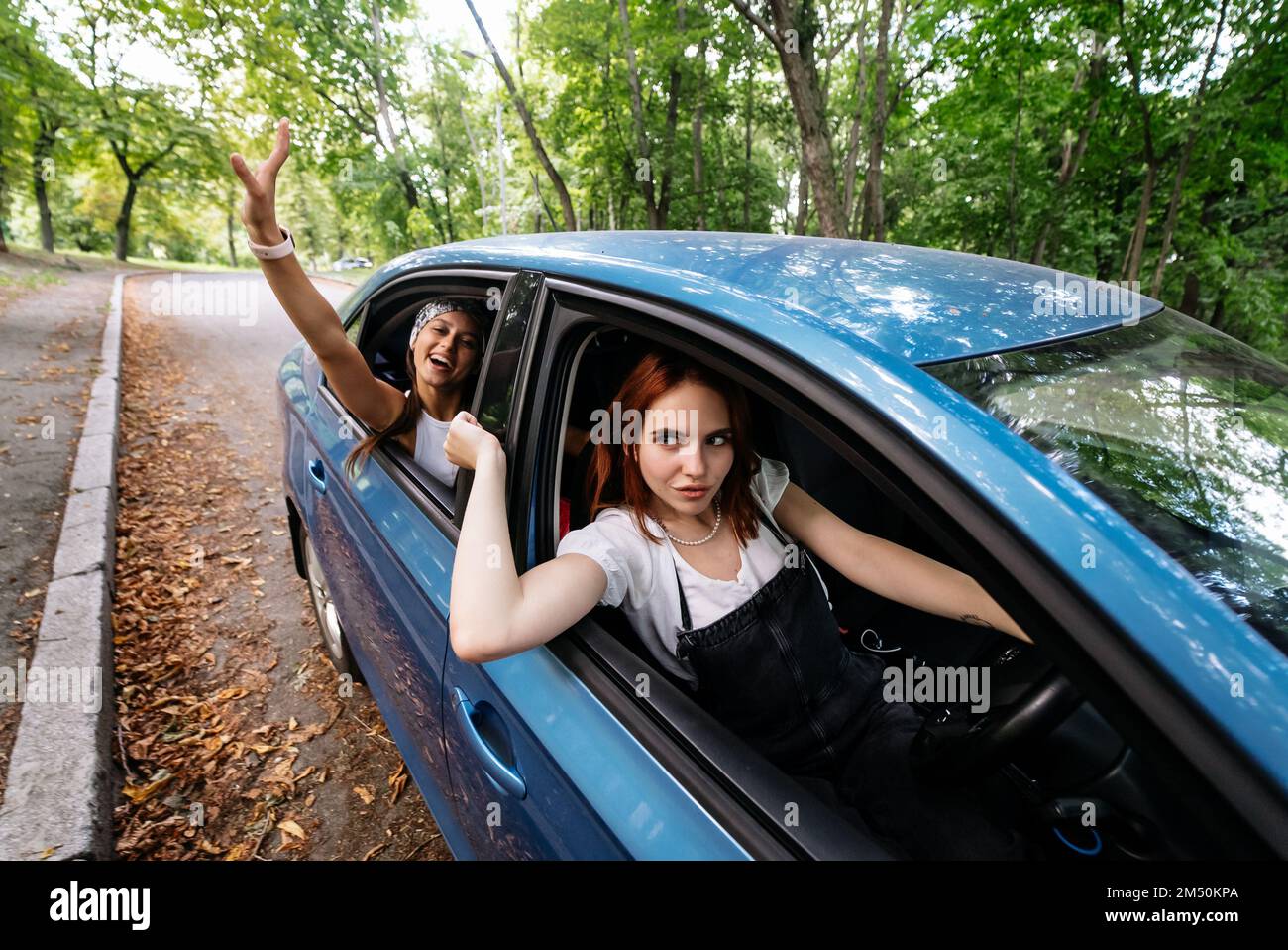 Two girlfriends fool around and laughing together in a car Stock Photo ...