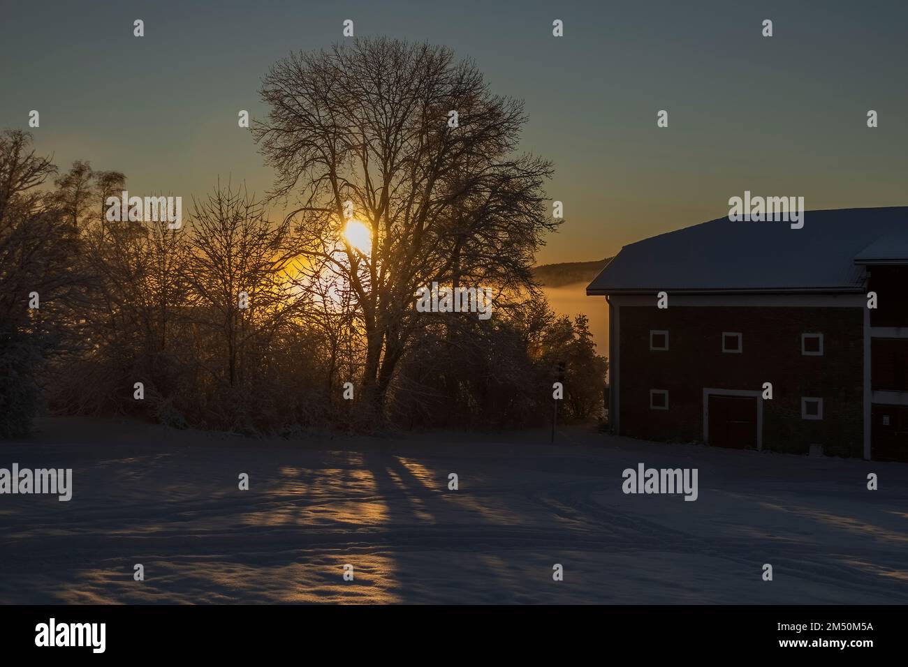 Sunset over lake Bysjön in Grangärde Sweden with mist covering the ice ...