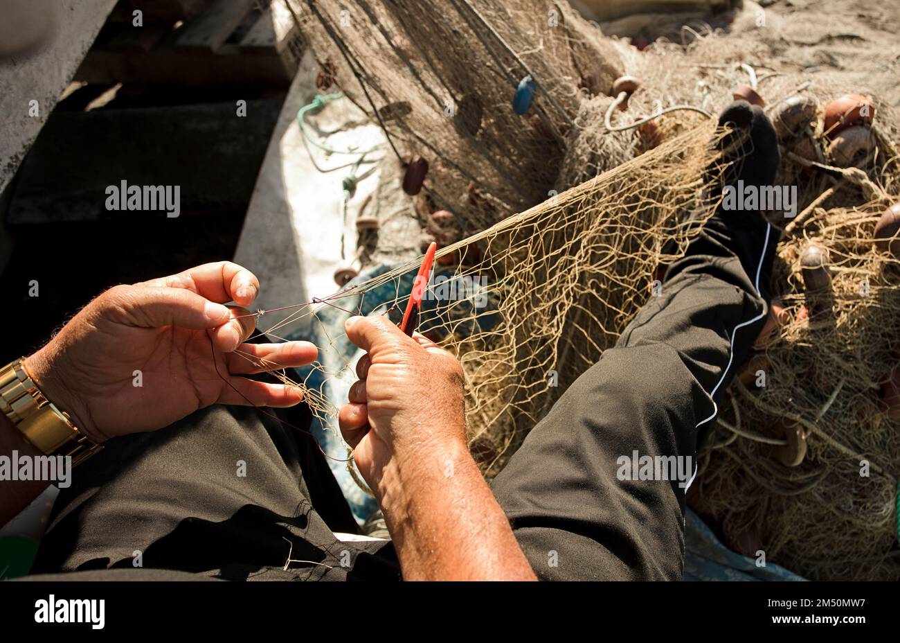 fishing net in the hands of fisherman, with needle and thread, grabs ...