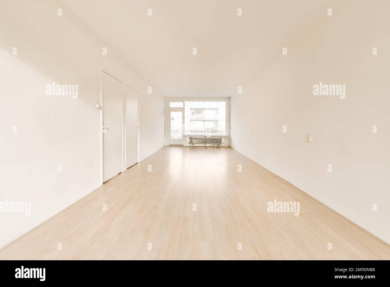 an empty room with white walls and wood flooring on the right, there is ...