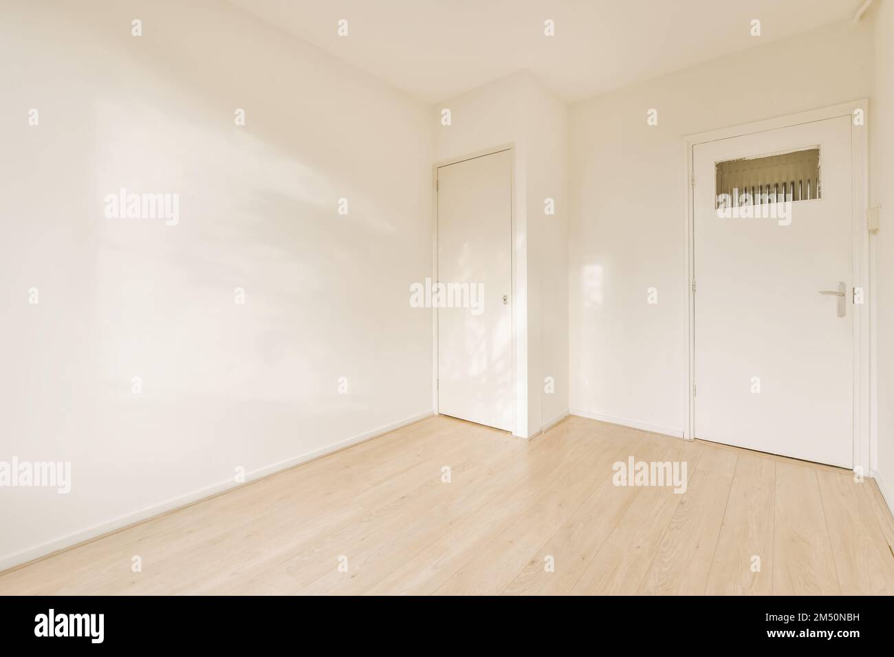 an empty room with white walls and wood flooring on the right side ...