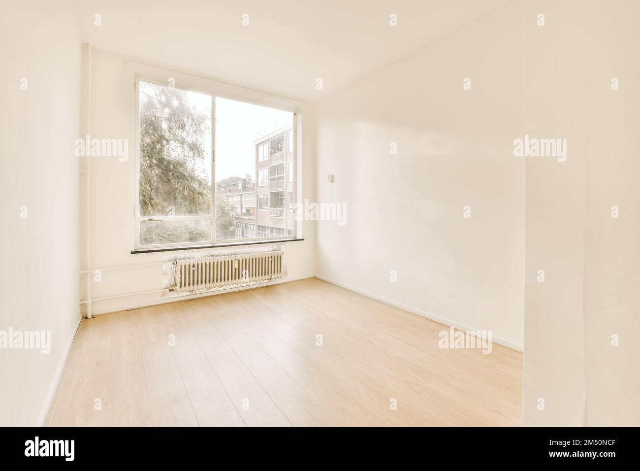 an empty room with white walls and wood flooring on the right, there is ...