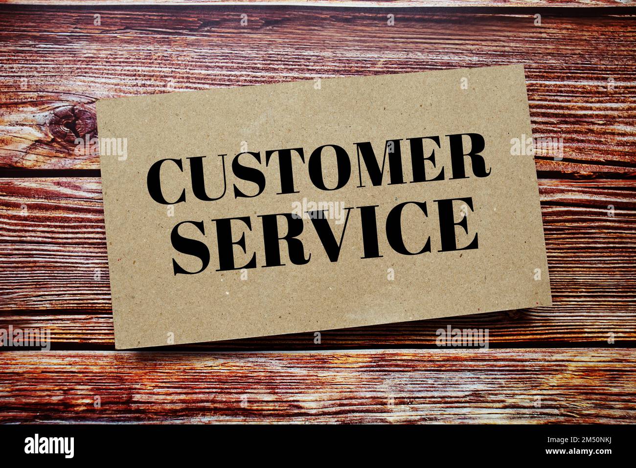 Customer Service written on paper card top view of wooden background ...