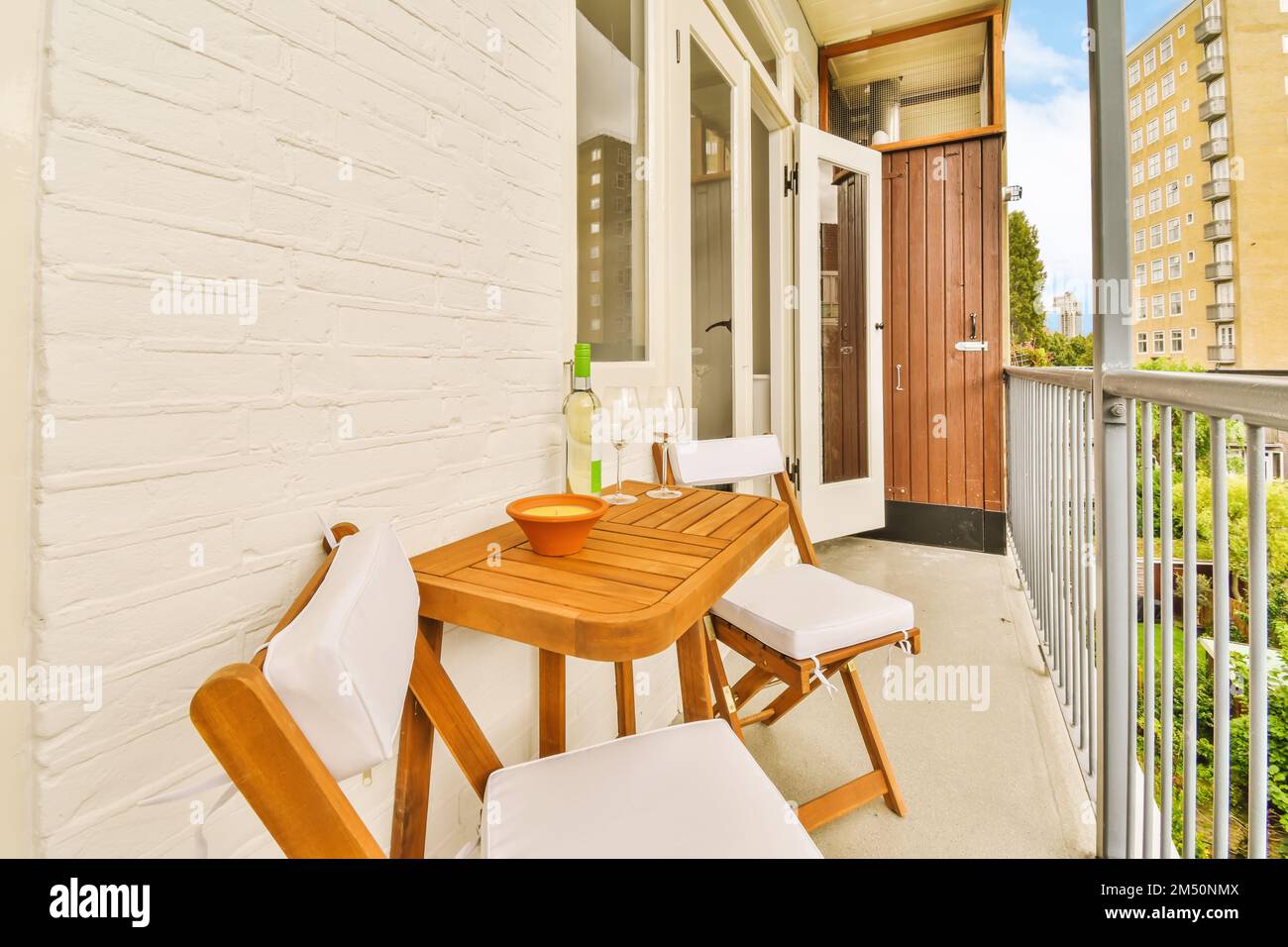 a balcony with two chairs and a small table on the left side of the ...
