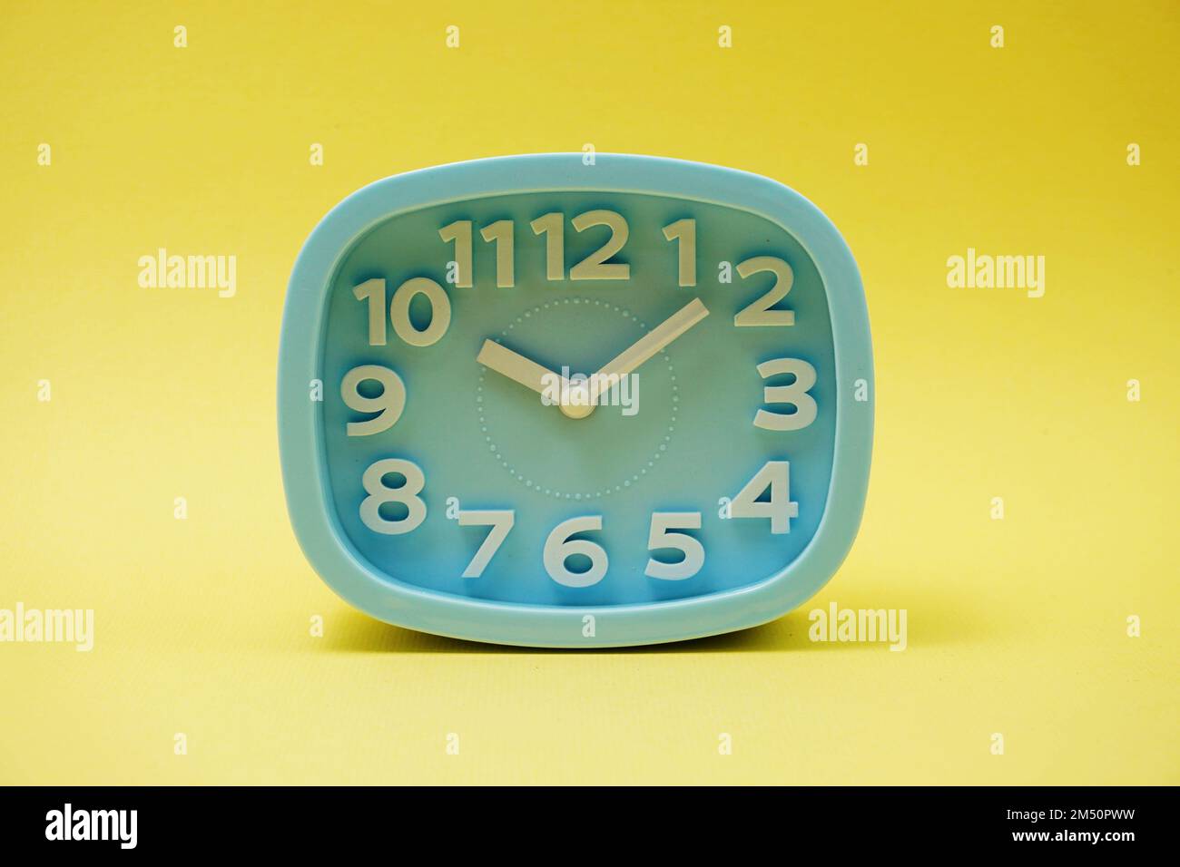 light blue alarm clock with space copy on yellow background Stock Photo ...