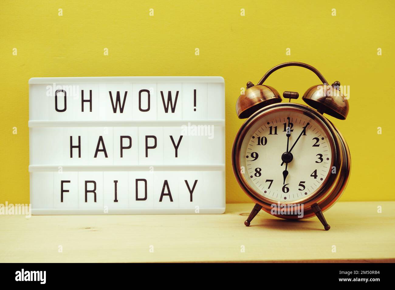 Happy Friday text in lightbox with alarm clock on yellow background ...