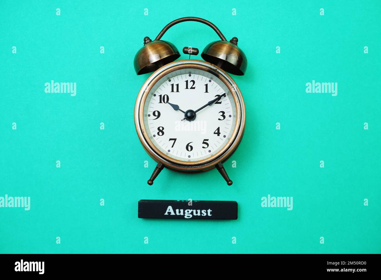 Alarm clock and August calendar with space copy on green mint ...