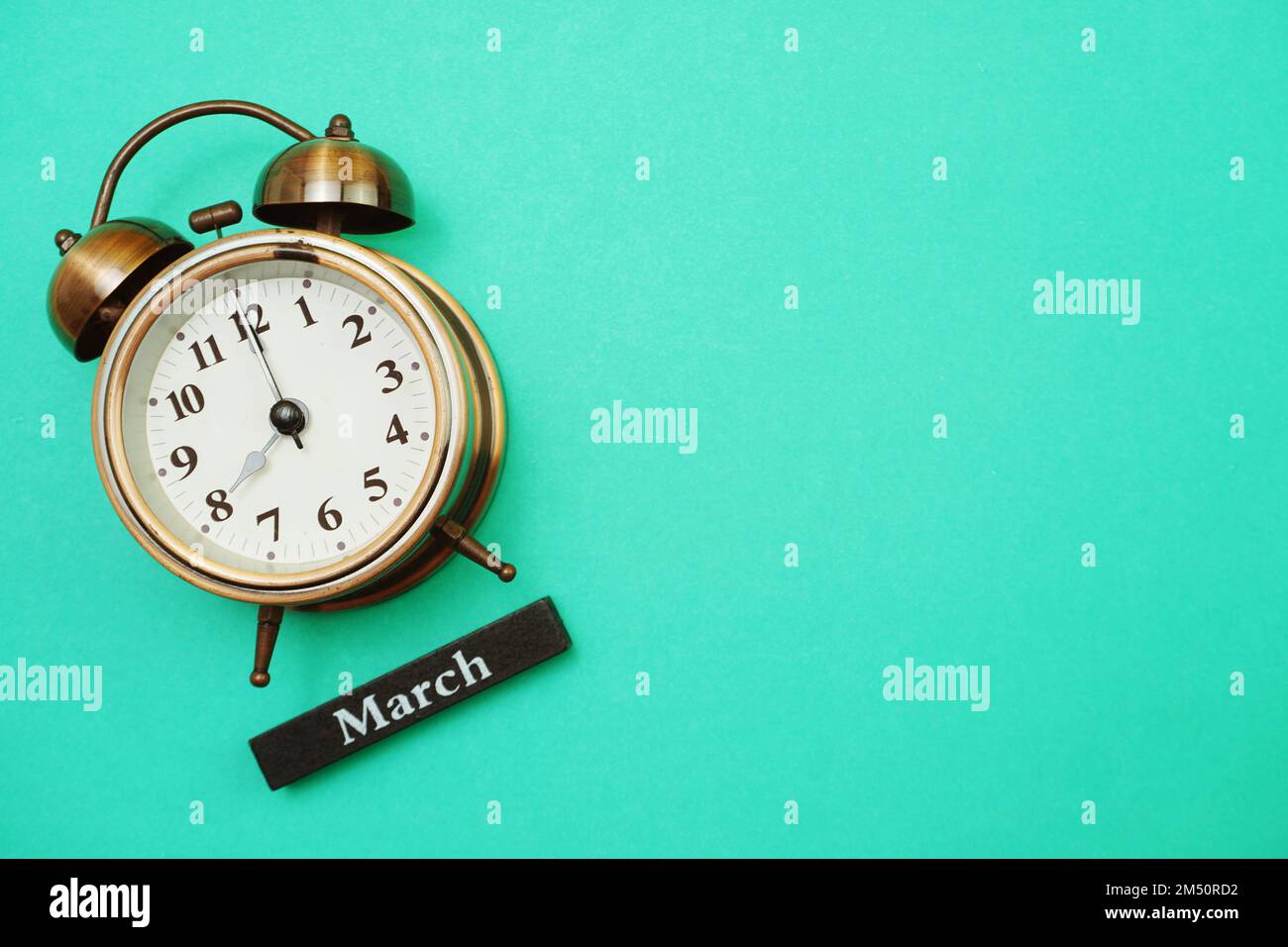 Alarm clock and March calendar with space copy on green mint background ...