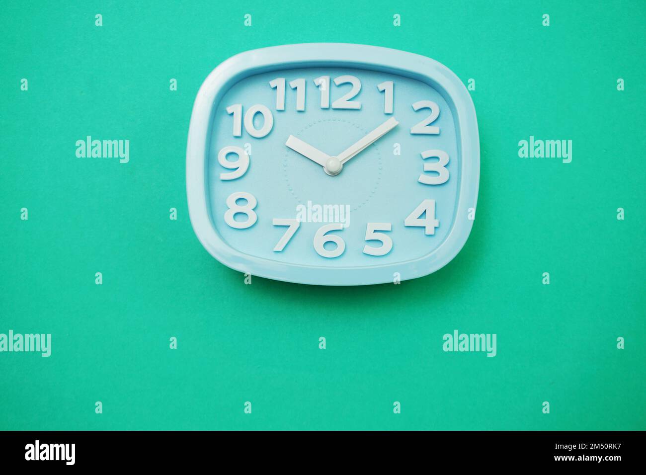 White round clock showing Ten o'clock on green background Stock Photo ...