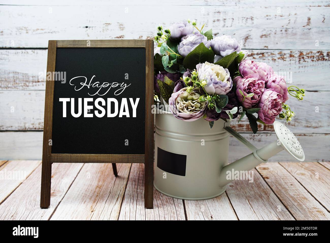 Happy Tuesday text on blackboard easel with flower bouquet on wooden ...