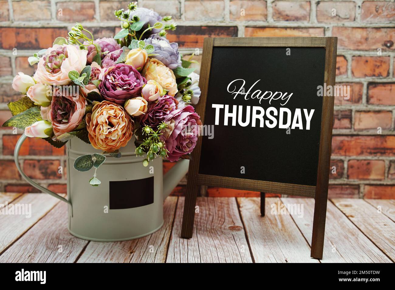 Happy Thursday text on blackboard easel with flower bouquet on wooden ...
