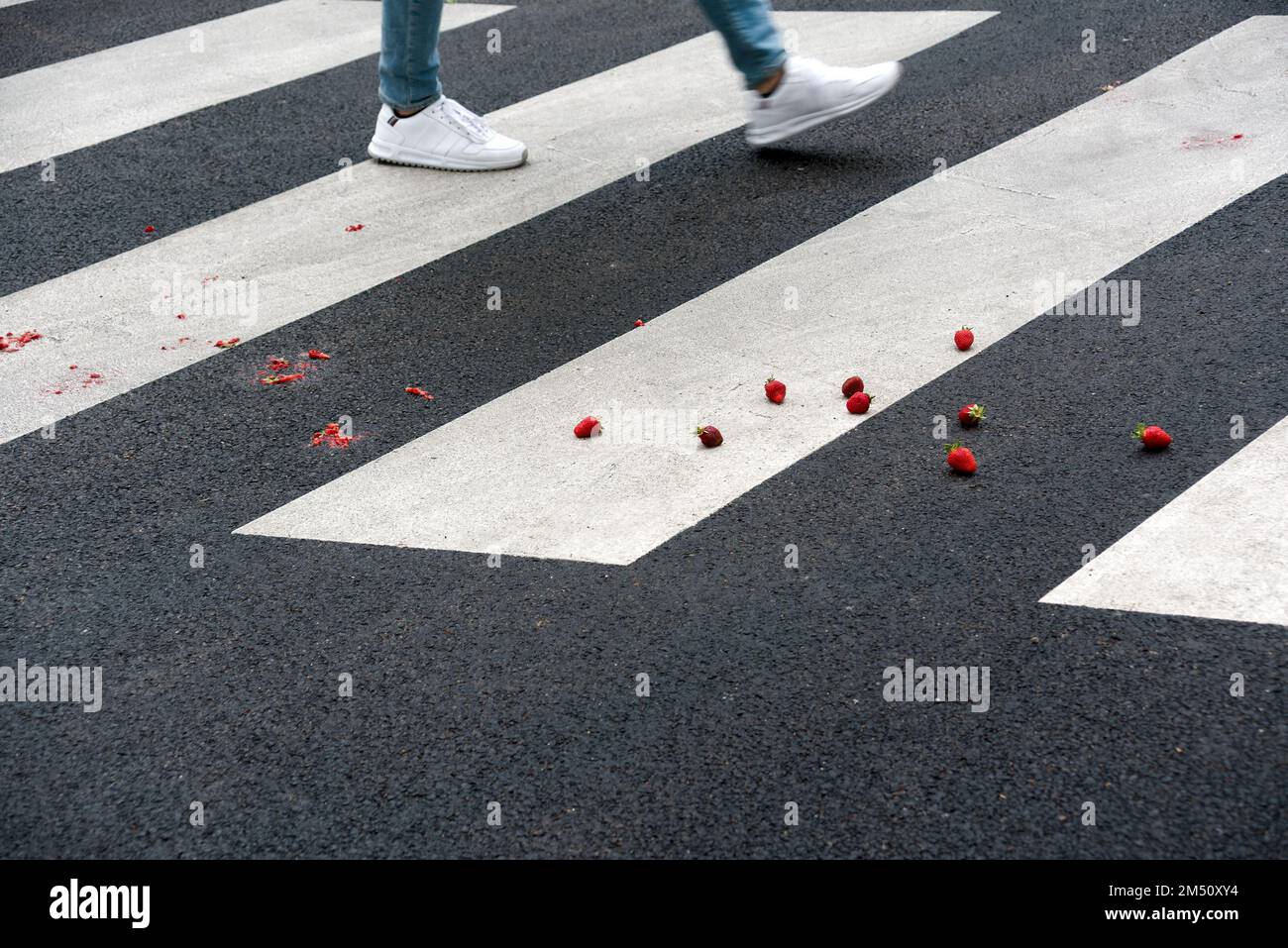 Squashed berries on the crosswalk against walking person feet Stock ...