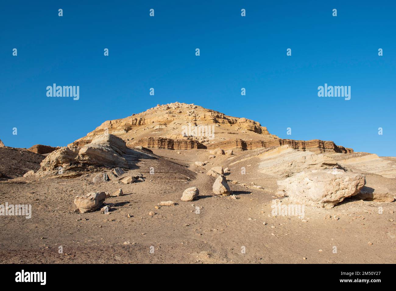 Rocky slope landscape in an arid desert environment with large pyramid ...