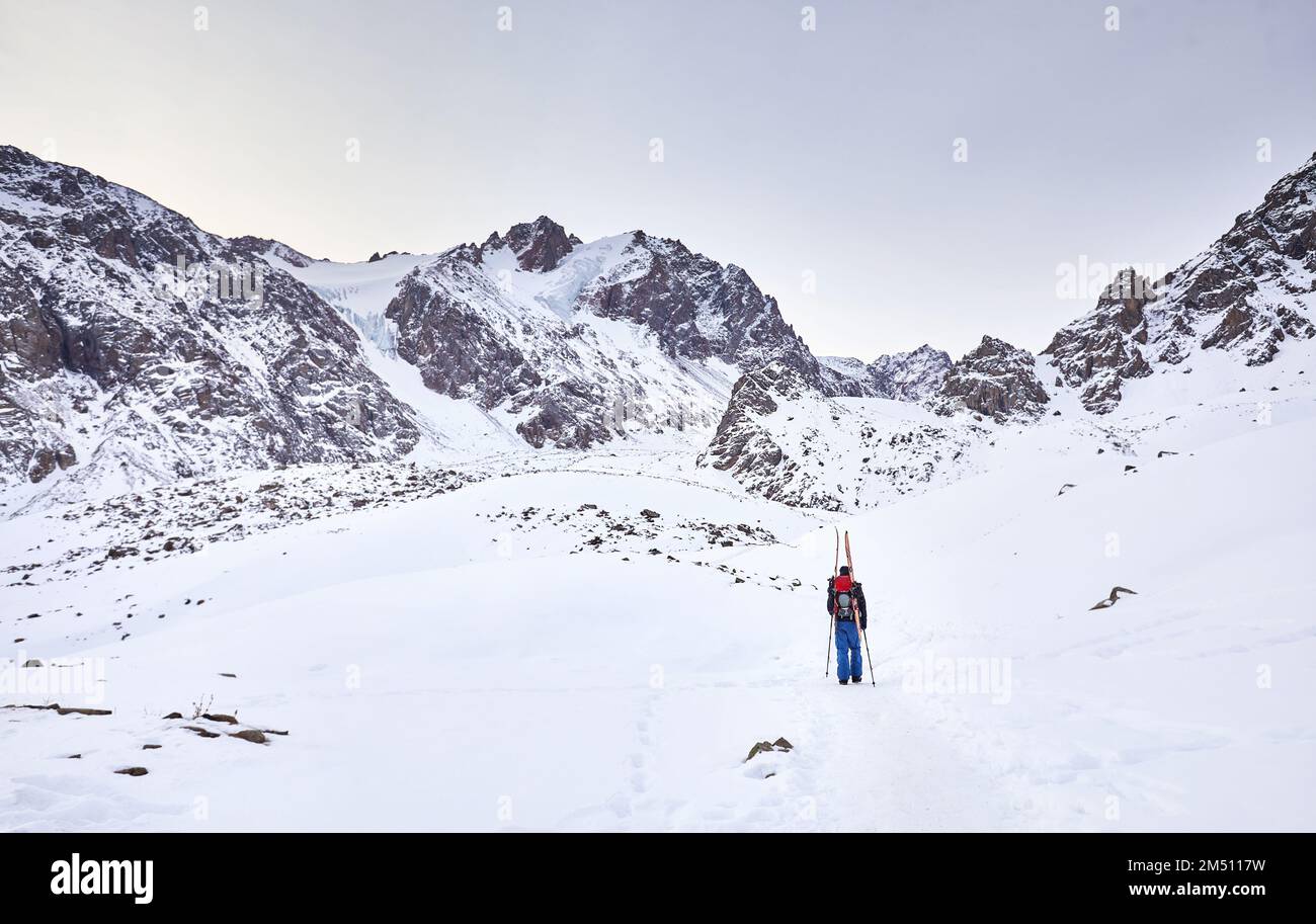 Skier man climbing with split board in high snowy mountains. Sport ...