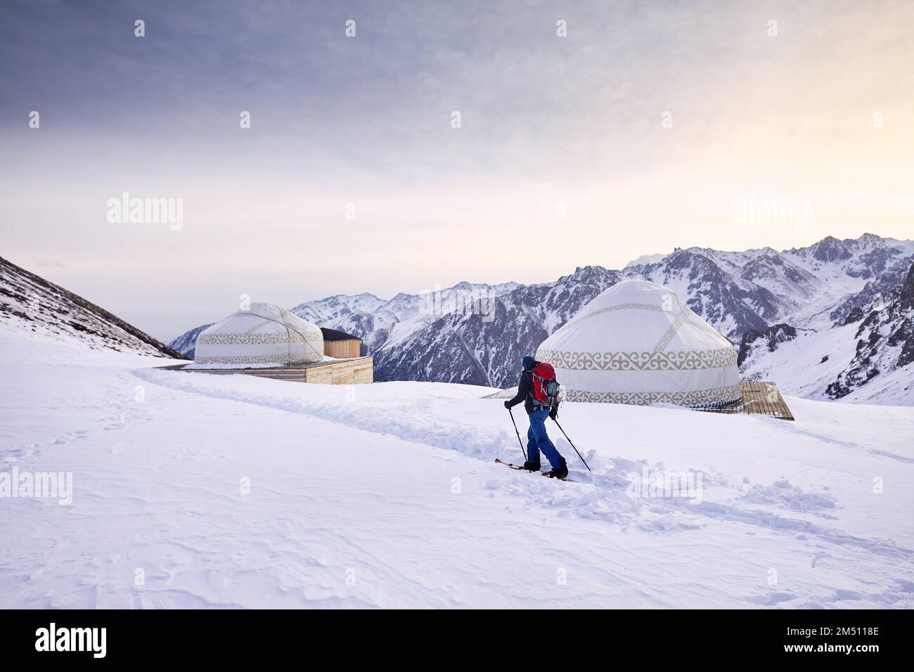 Skier man ski touring with backpack at high snowy mountain near ...