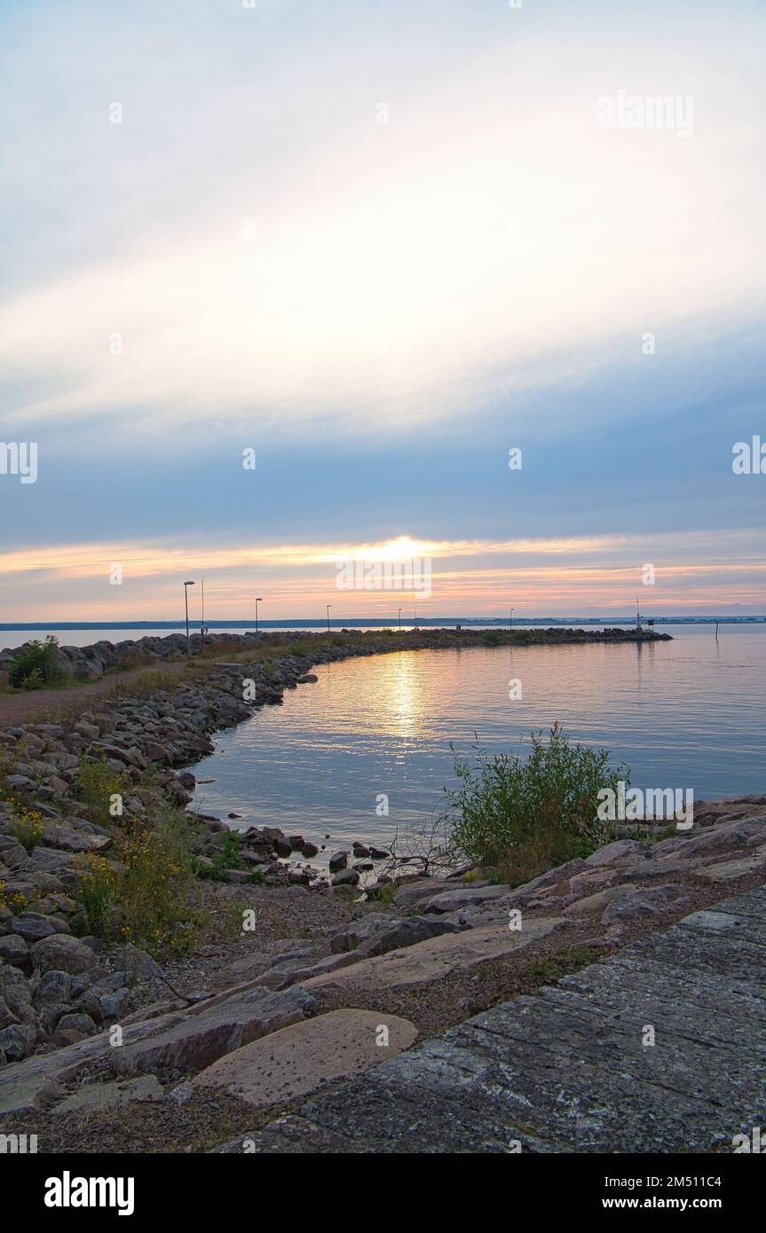 A vertical shot of a sunset in Sweden at the harbor of lake Vattern ...