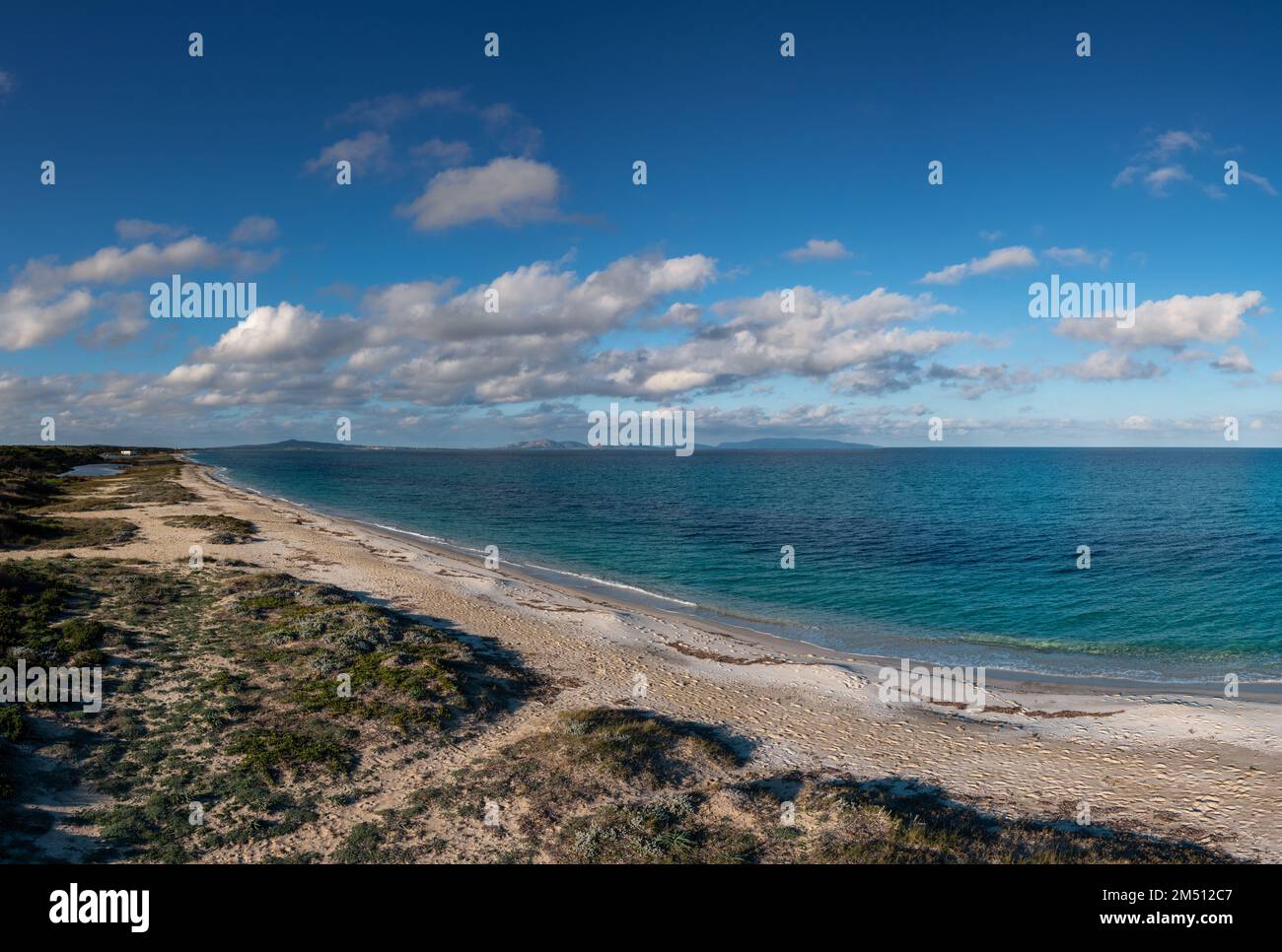 An aerial view of a secluded and long sandy beach with turquoise ocean ...