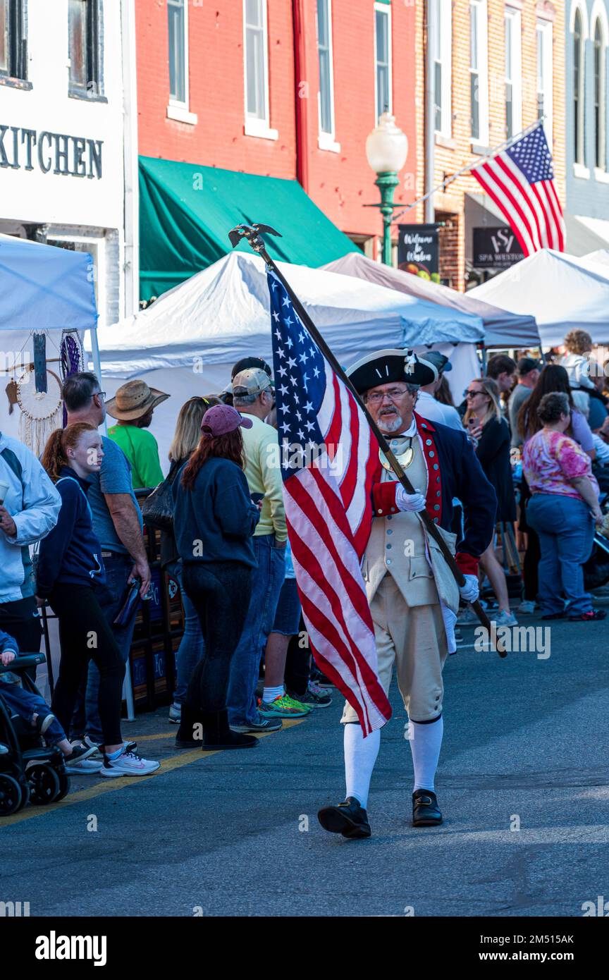 A vertical shot of a Flag bearer in colonial garments during the ...